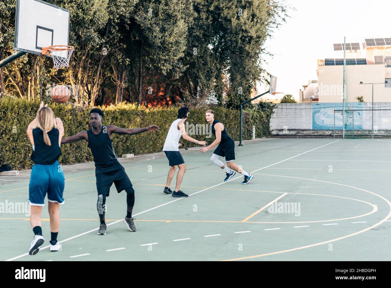 Woman passing the ball during a basketball game between friends ...