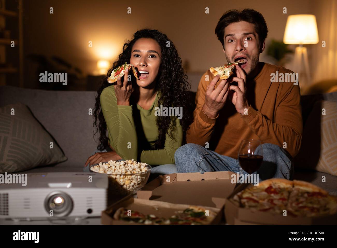 Couple Eating Pizza Watching New Movie Sitting At Home Stock Photo - Alamy