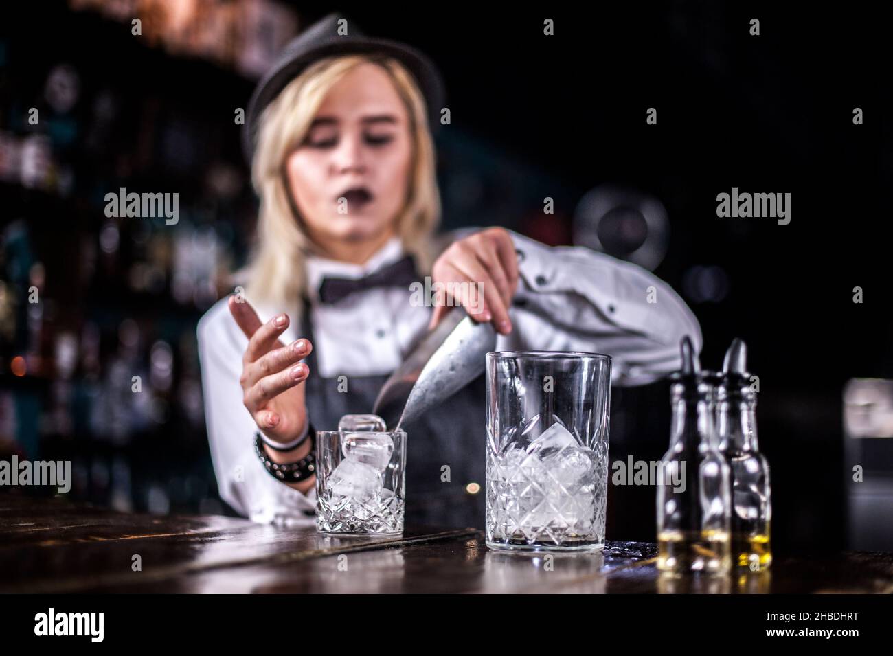 Sweet barmaid formulates a cocktail Stock Photo - Alamy