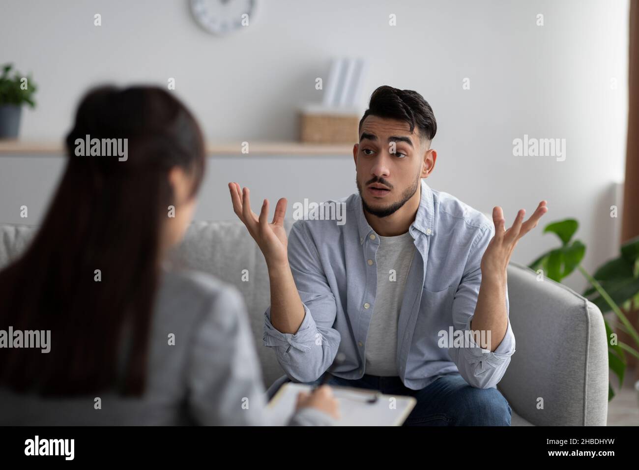 Emotional arab man having session with psychologist, sitting on couch ...