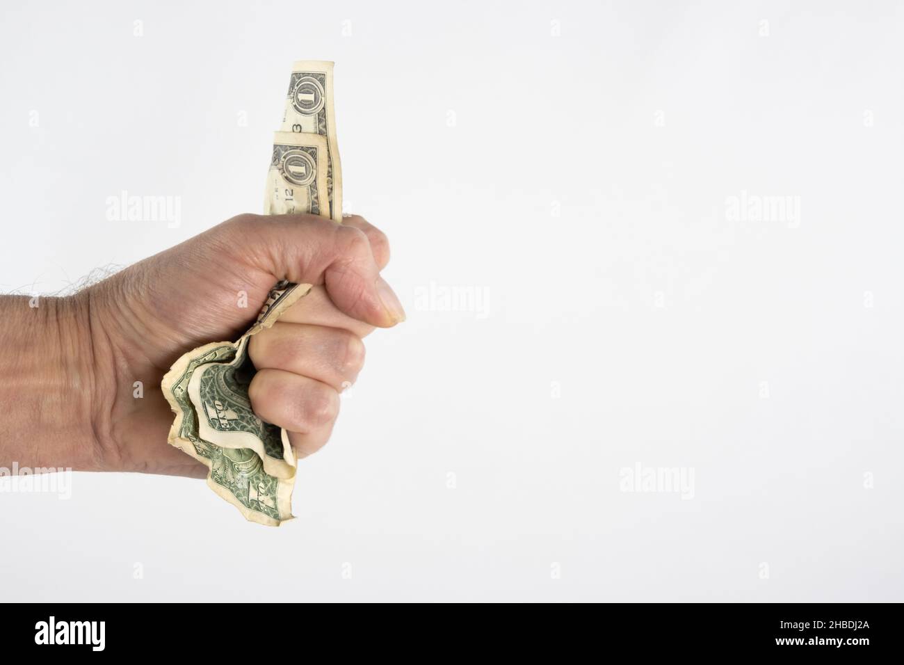 A hand holding a handful of us dollar bills on white background and ...
