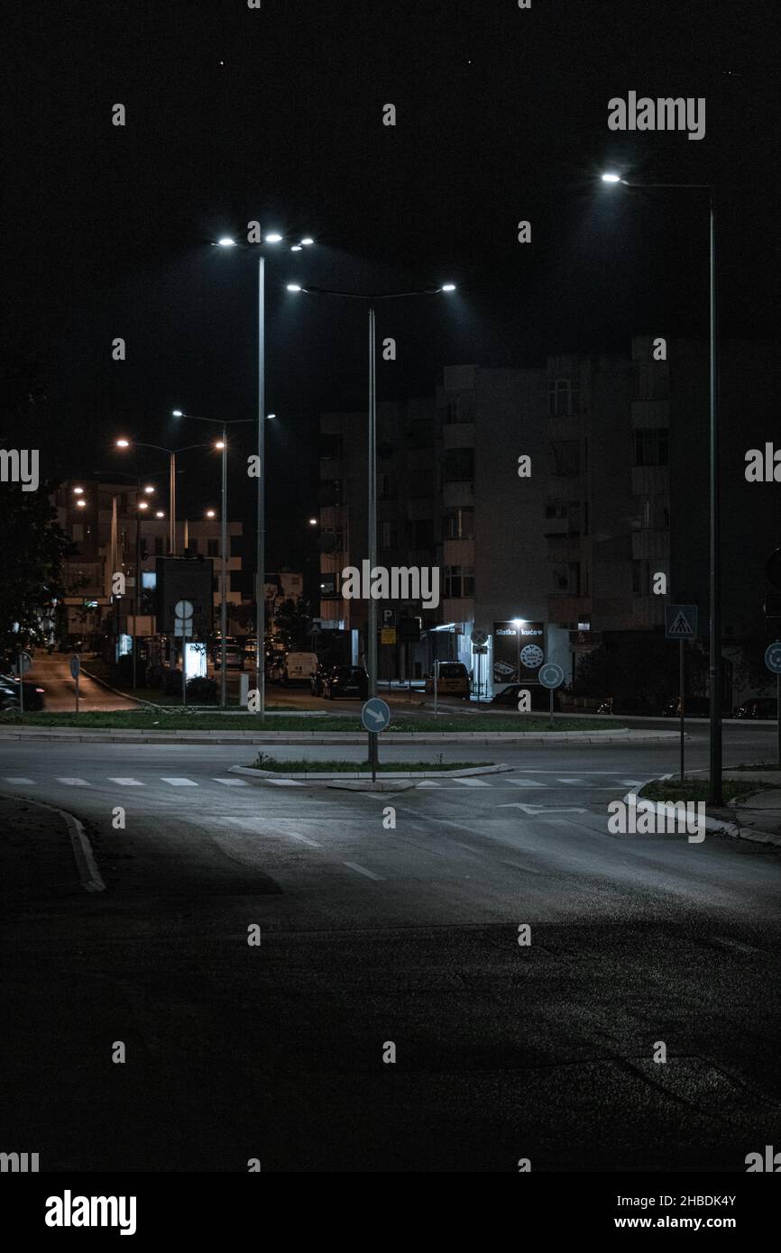 An illuminated town and long exposure car lights on a roundabout at ...