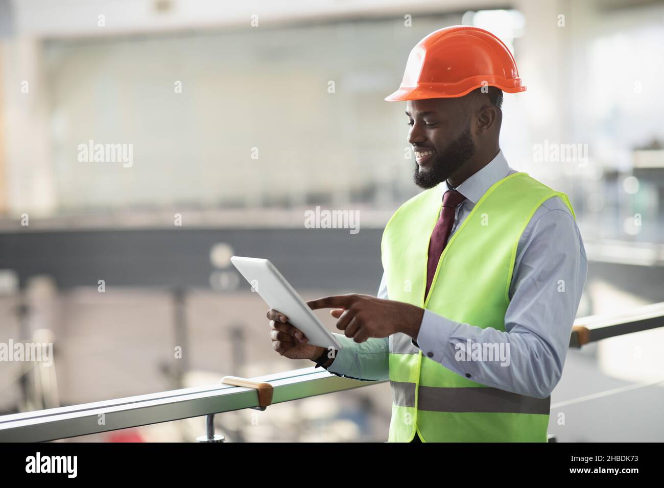 Smiling african american civil engineer with digital tablet, side view ...