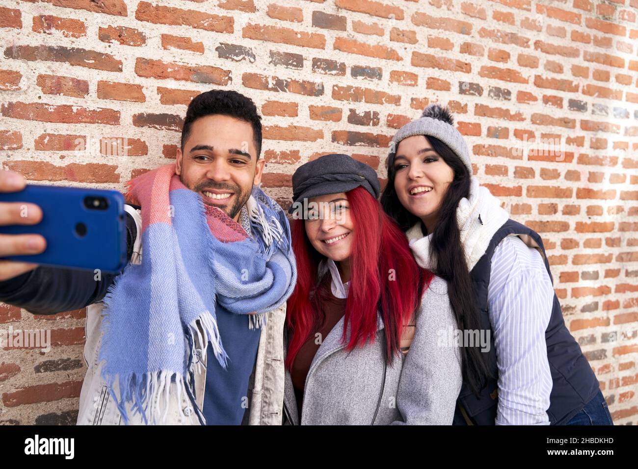 Positive multiracial male and female friends in stylish outfits smiling ...