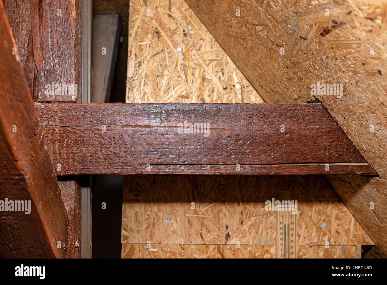 Roof truss visible in the attic house, painted brown with visible ...