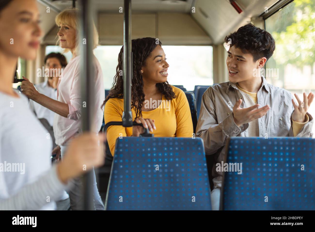 Happy young multiciltural friends taking bus together Stock Photo - Alamy