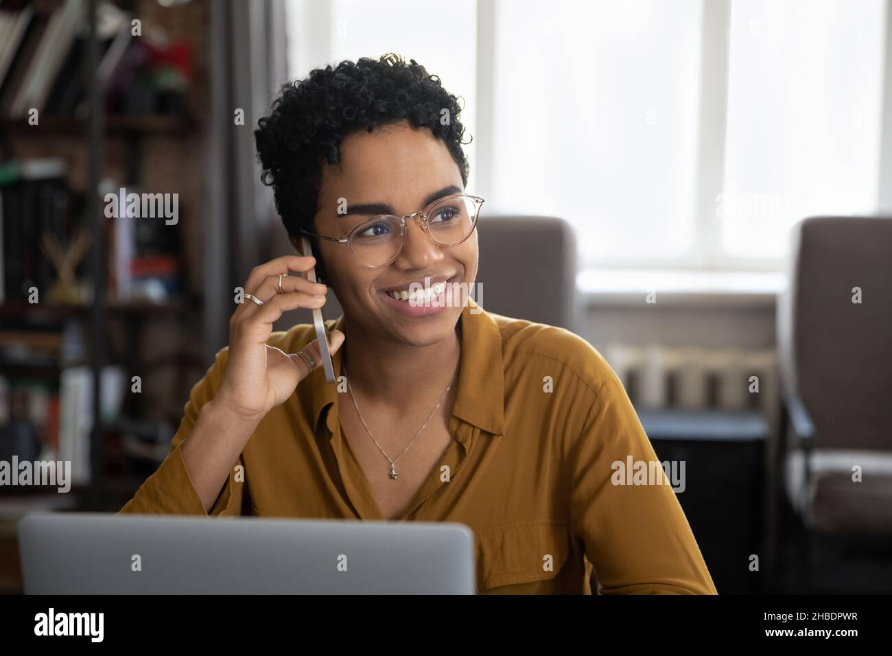 Happy African American businesswoman multitasking at home office Stock ...