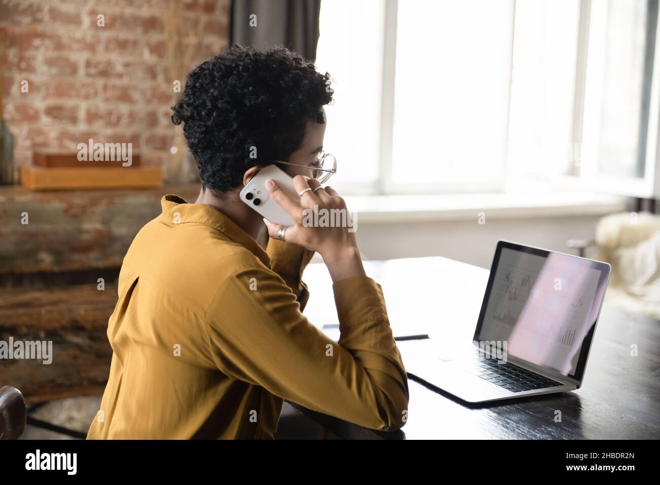 Focused female African American businesswoman multitasking in modern ...