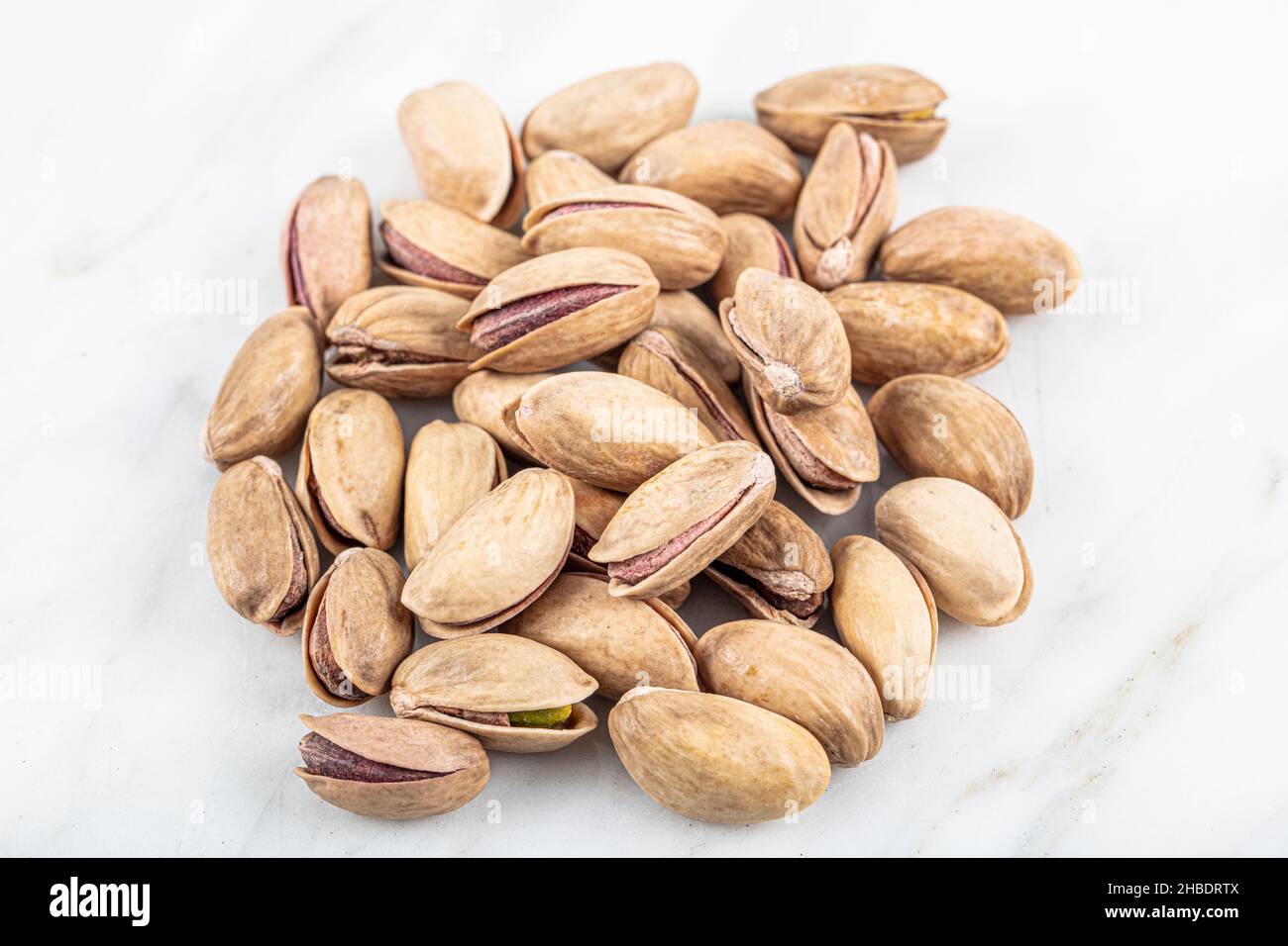 Pile of pistachios in the peel close-up. Pistachio isolated on marble ...