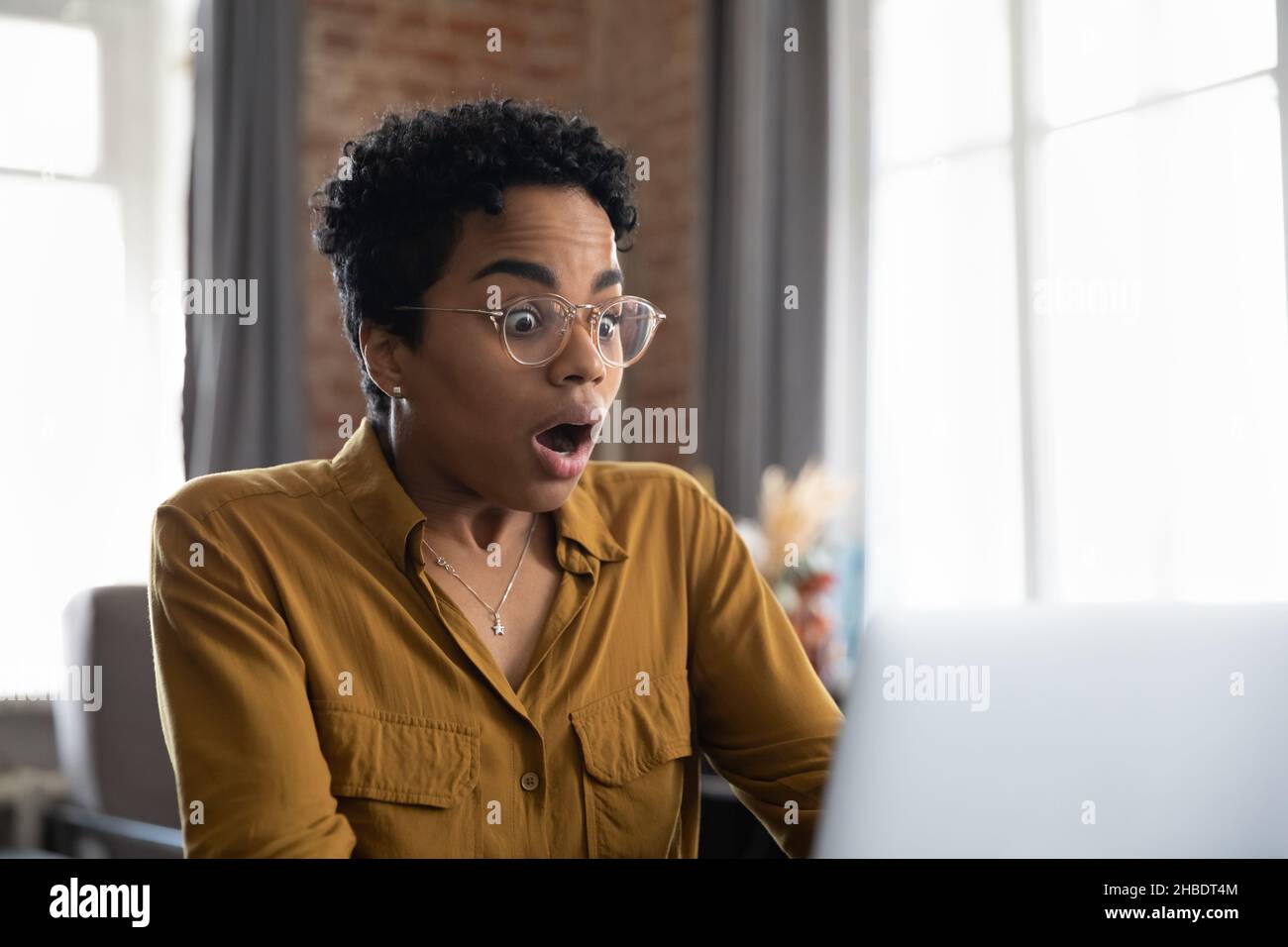 Shocked young African American woman getting email with unbelievable ...