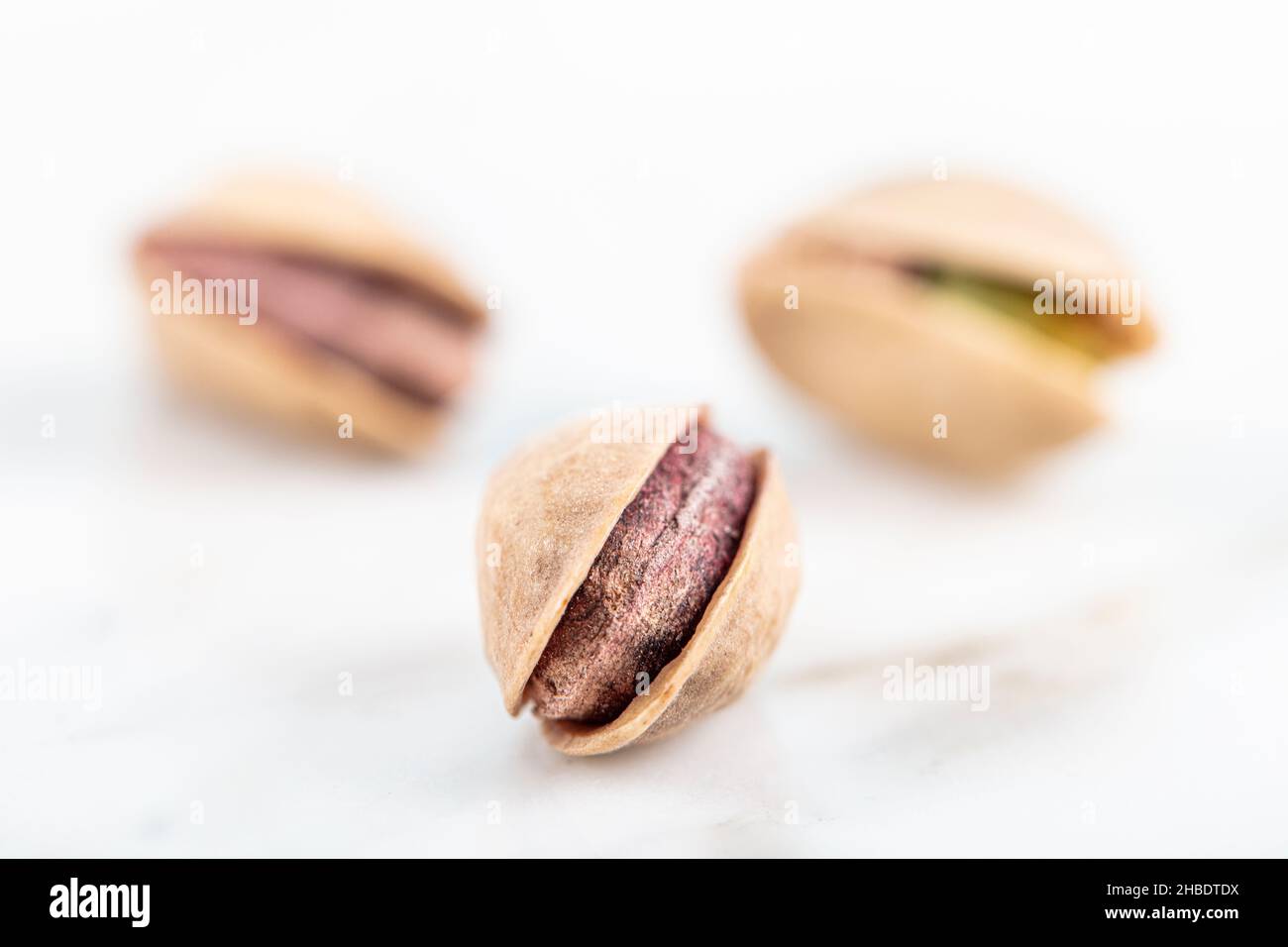 Pile of pistachios in the peel close-up. Pistachio isolated on marble ...