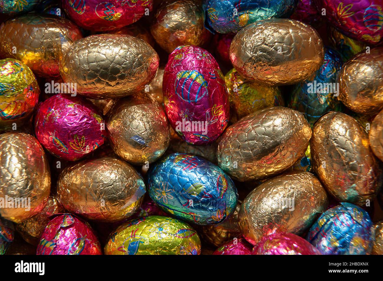 Full-frame close-up on a stack of colorful foil wrapped chocolate ...
