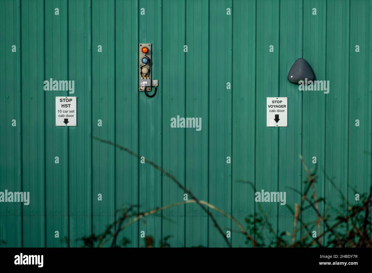 warning traffic light on green wooden building Stock Photo - Alamy