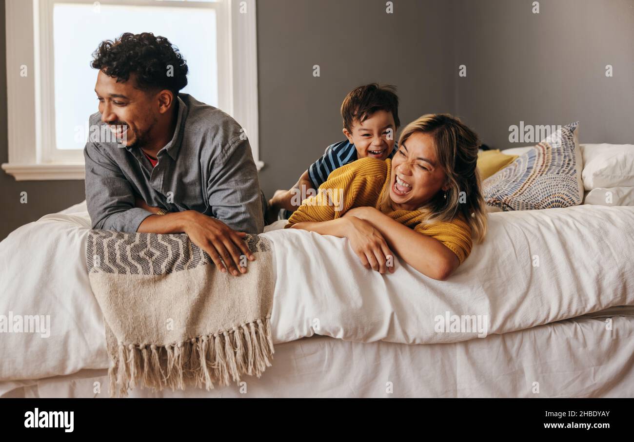 Ethnic parents laughing and having fun with their son at home. Two ...