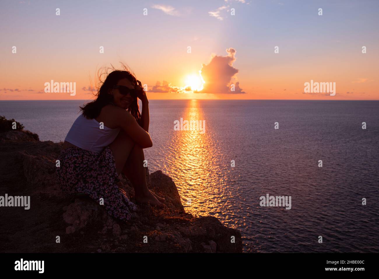 Woman enjoying sunset above sea hi-res stock photography and images - Alamy