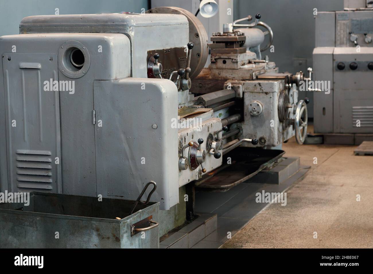Old lathe stands in lathe shop in factory. Empty workspace. No people ...