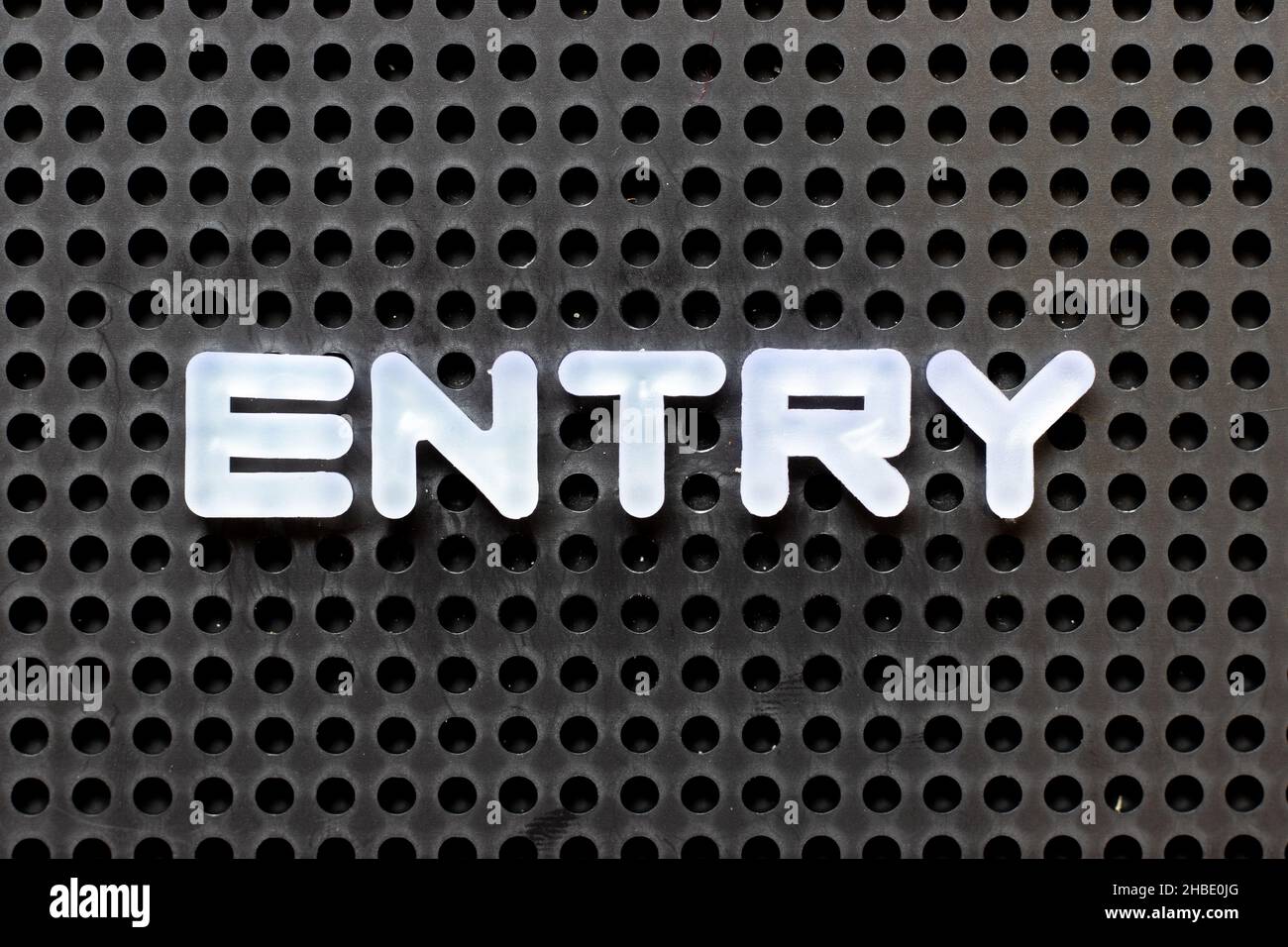 White color alphabet with word entry on black pegboard background Stock ...