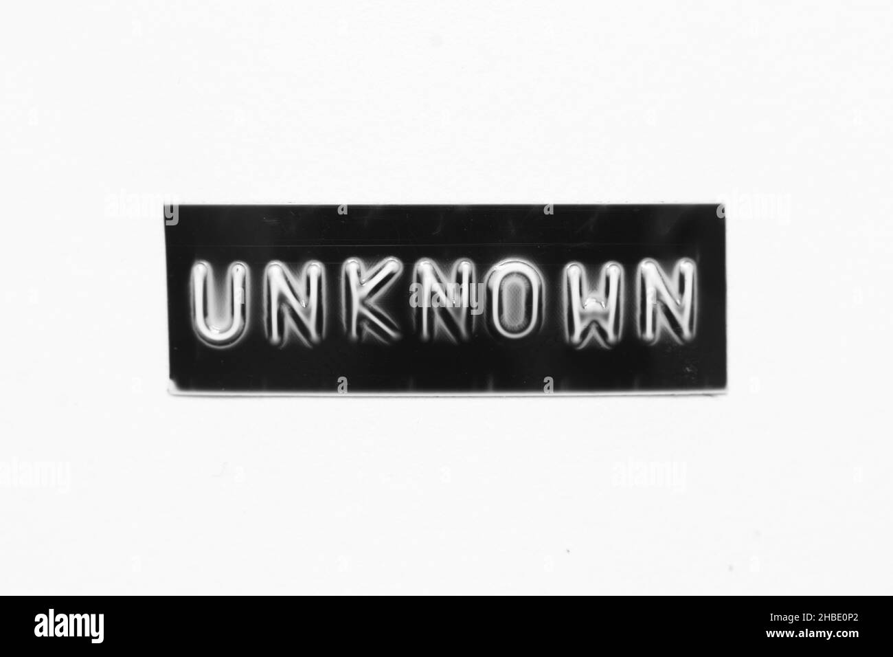 Black color banner that have embossed letter with word unknown on white ...
