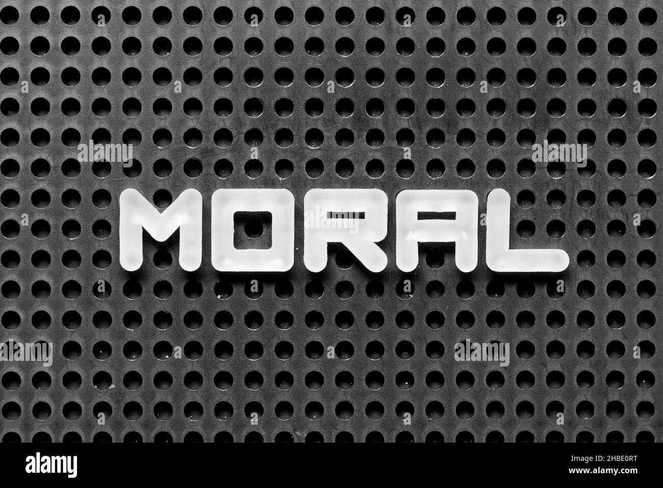 White alphabet letter in word moral on black pegboard background Stock ...