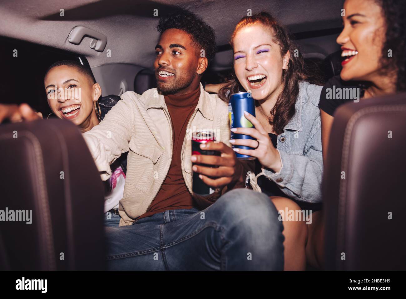 Riding home with joy. Group of four happy friends laughing cheerfully ...