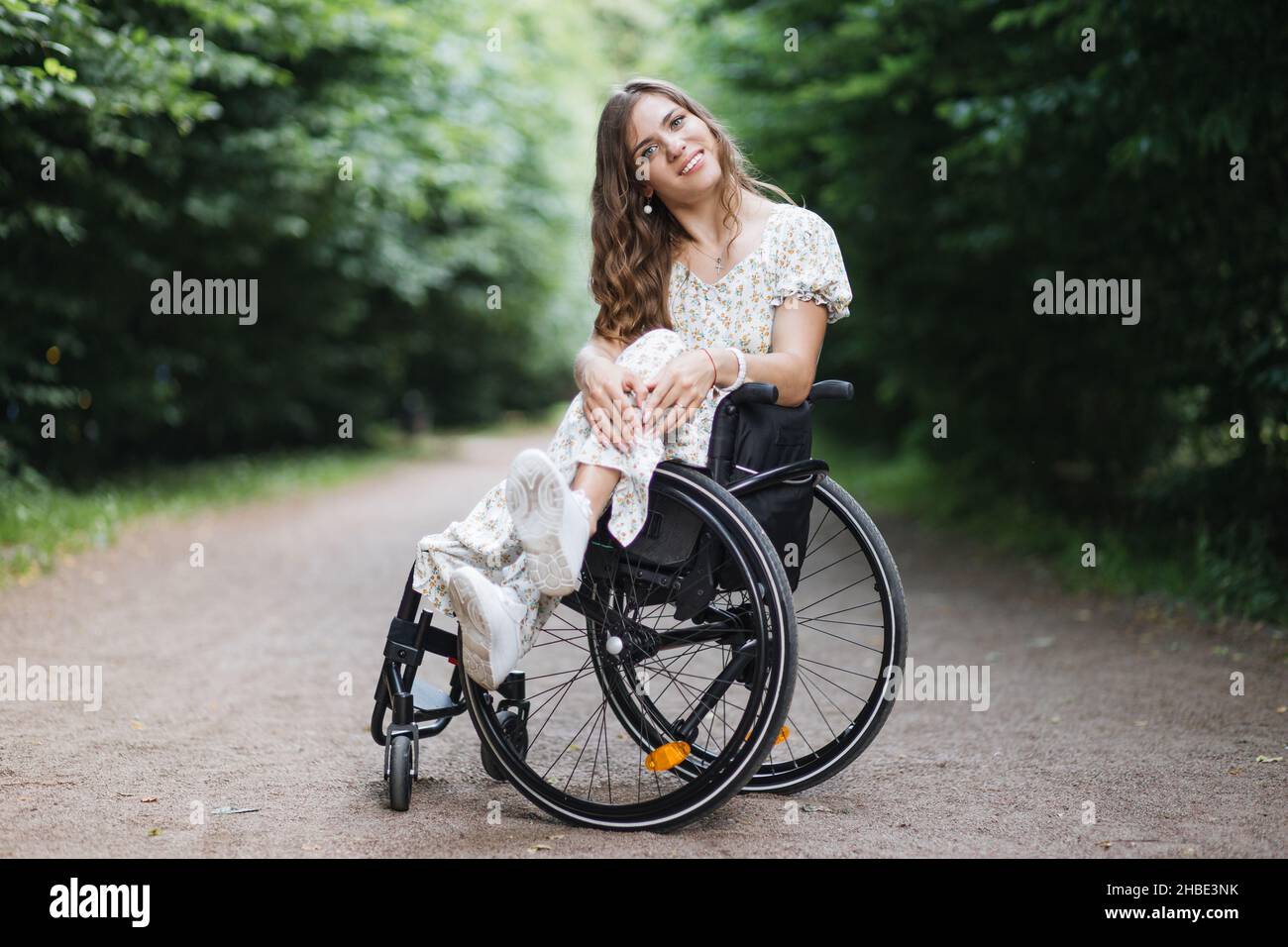 Dreamy caucasian woman with physical disability sitting in wheelchair ...
