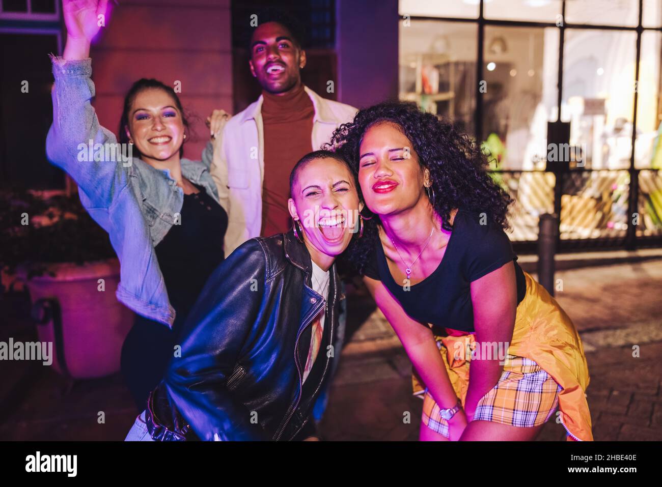 Energetic friends having fun together at night. Group of multicultural ...