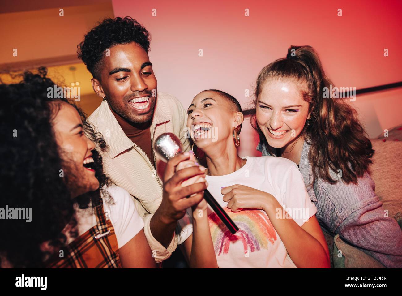 Vibrant friends singing their favourite song during karaoke night ...