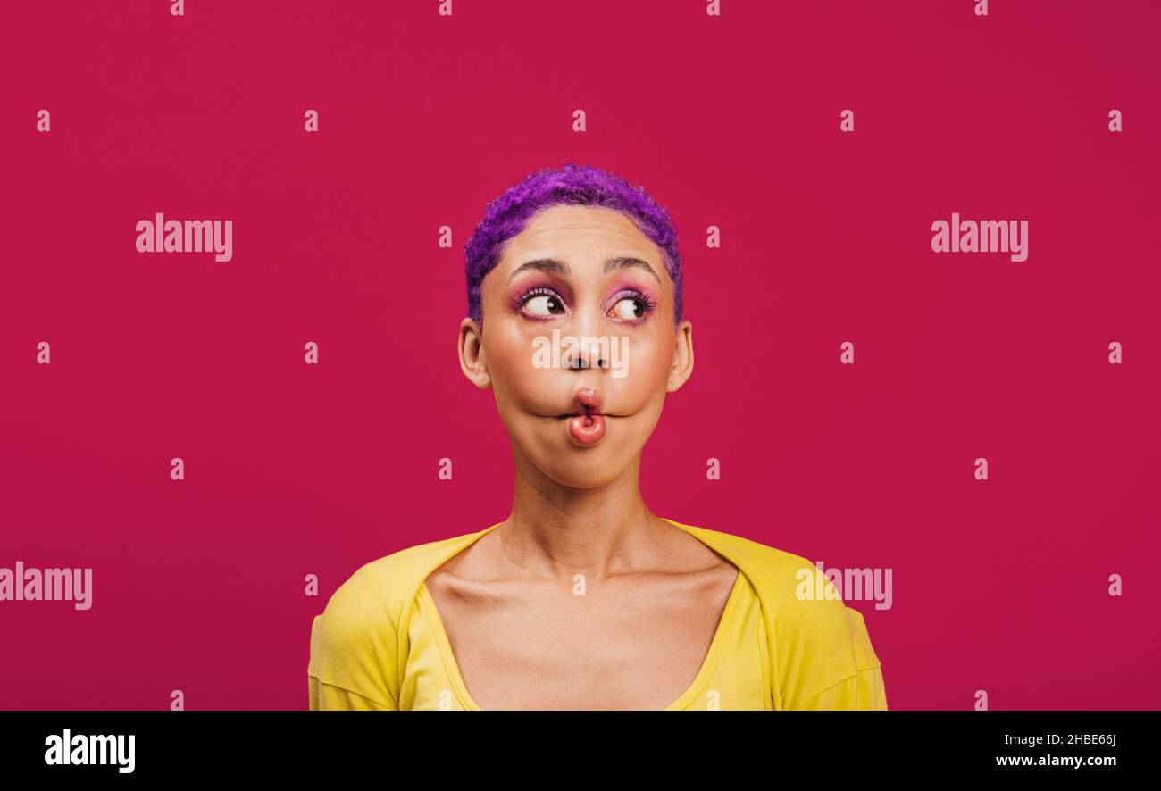 Making a silly face. Quirky young woman making a funny face while ...