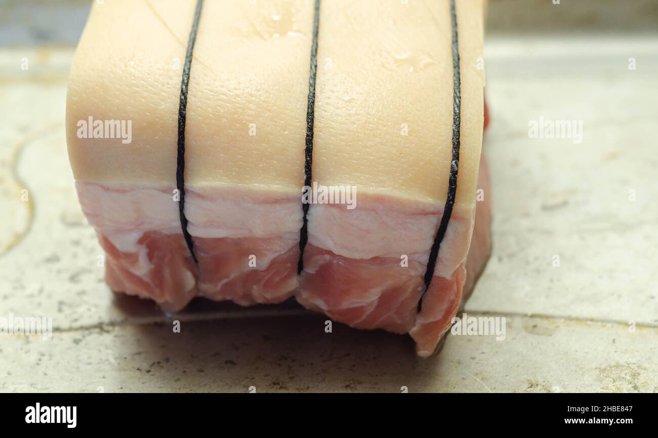 Boneless pork loin joint tied with string on the oven tray, raw meat ...