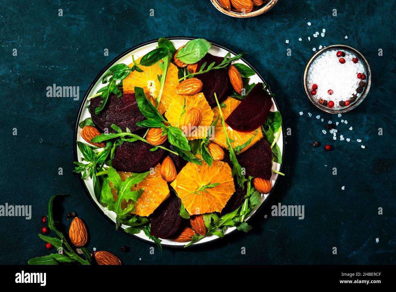 Beet Salad with orange, arugula and almonds on blue table background ...