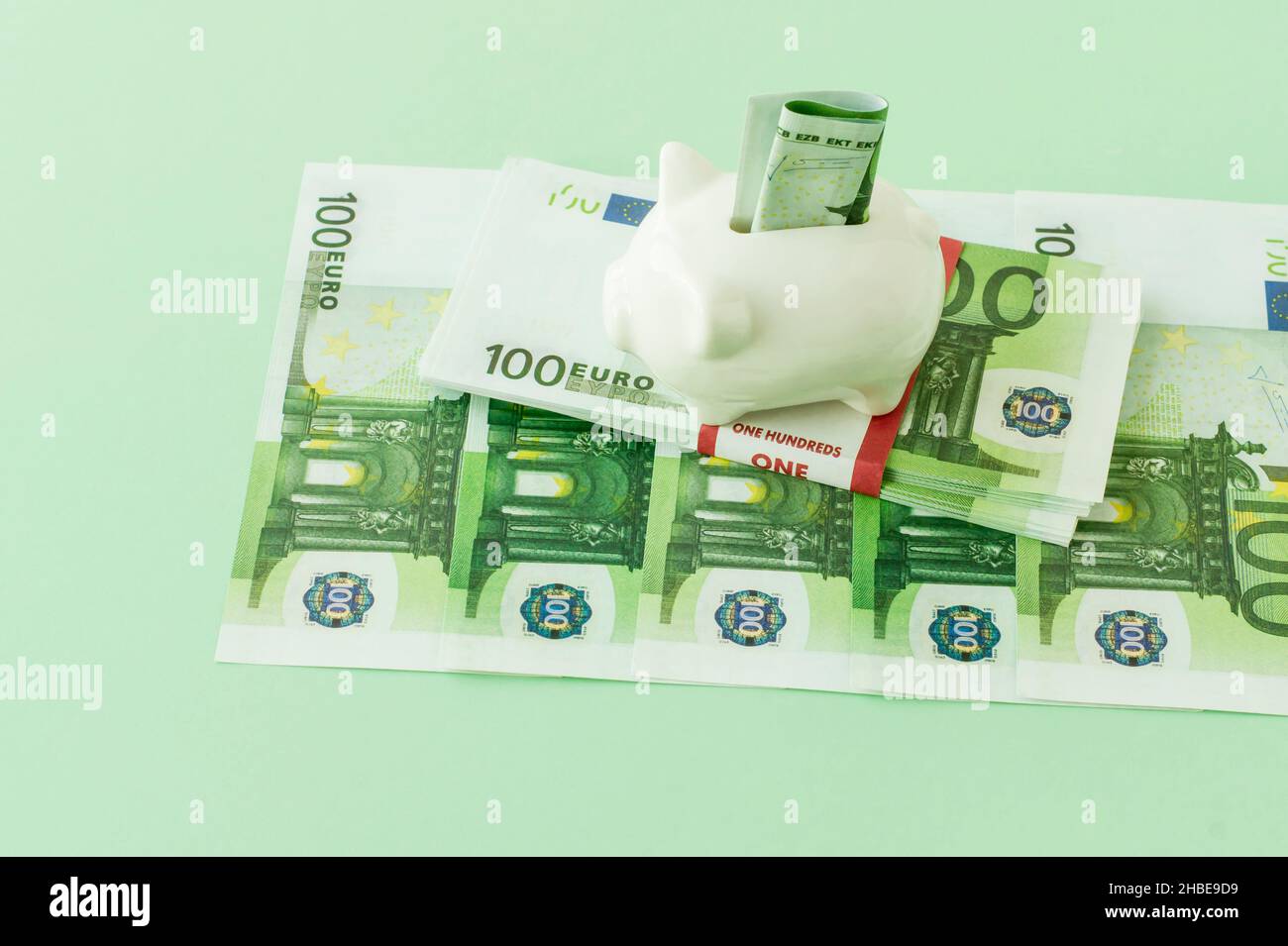 a pack of one hundred euros banknotes in a bank package with a piggy ...
