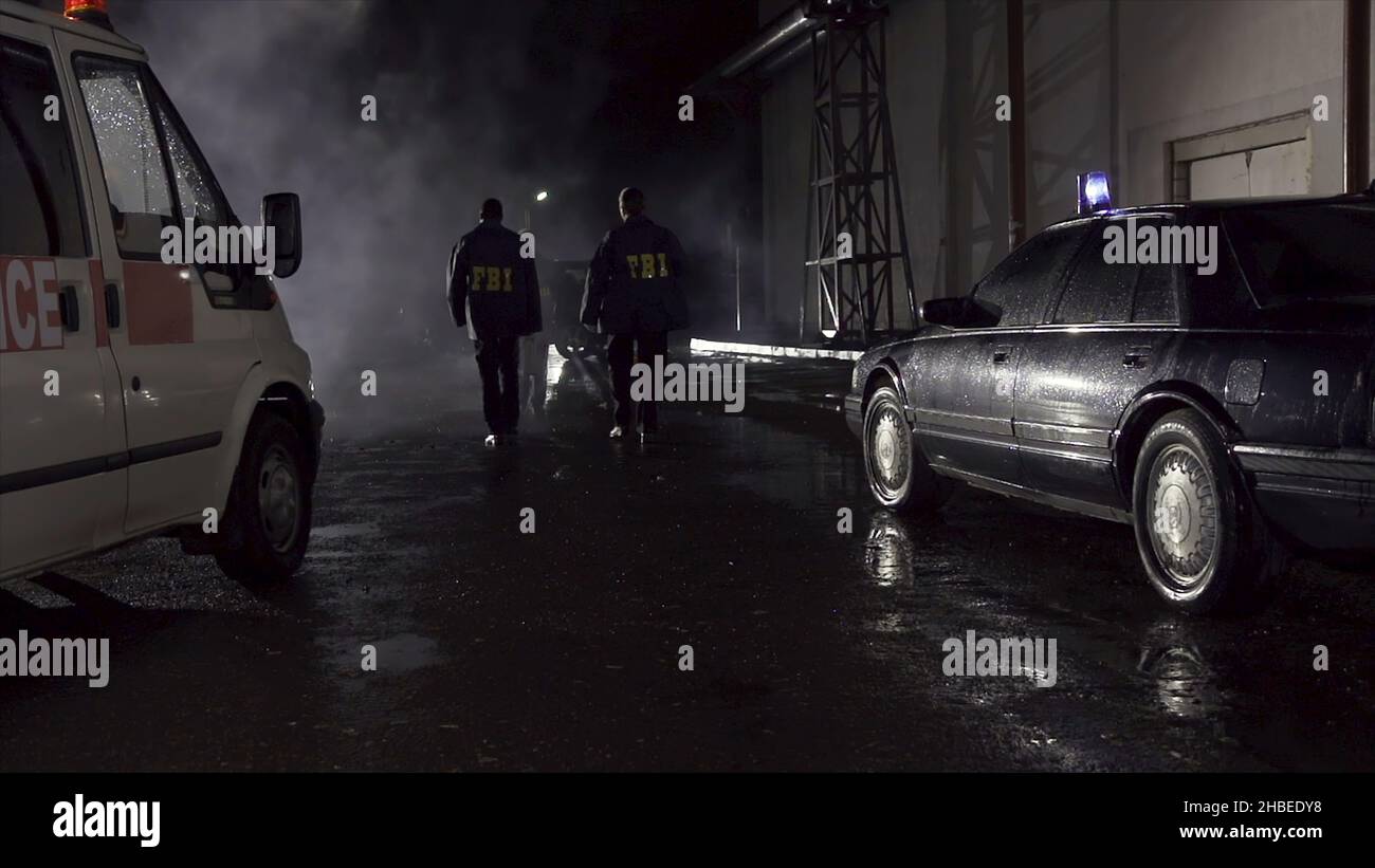 FBI agents work at the scene at night, police car with lights and ...
