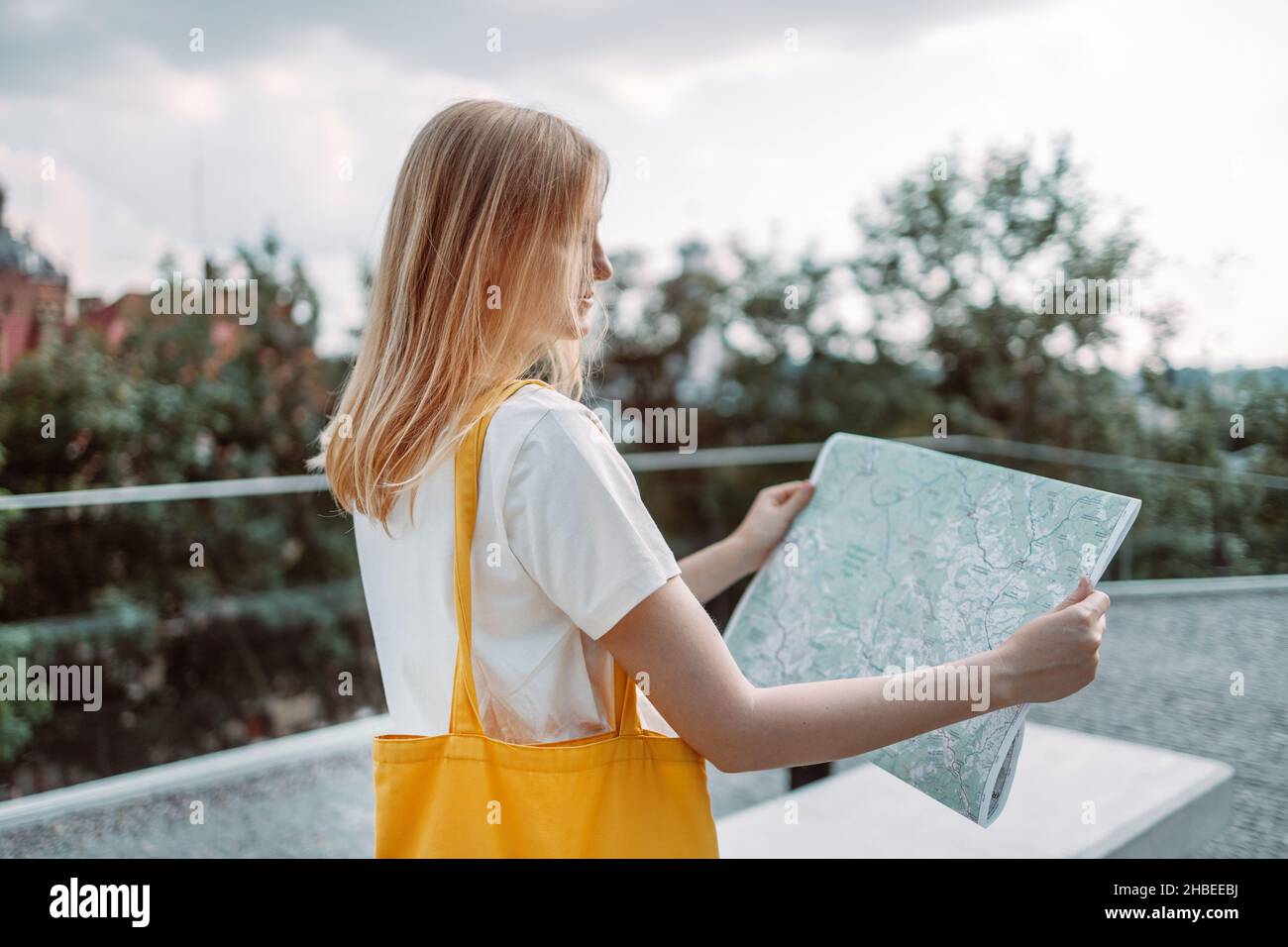 Young woman tourist checking a city map Stock Photo - Alamy