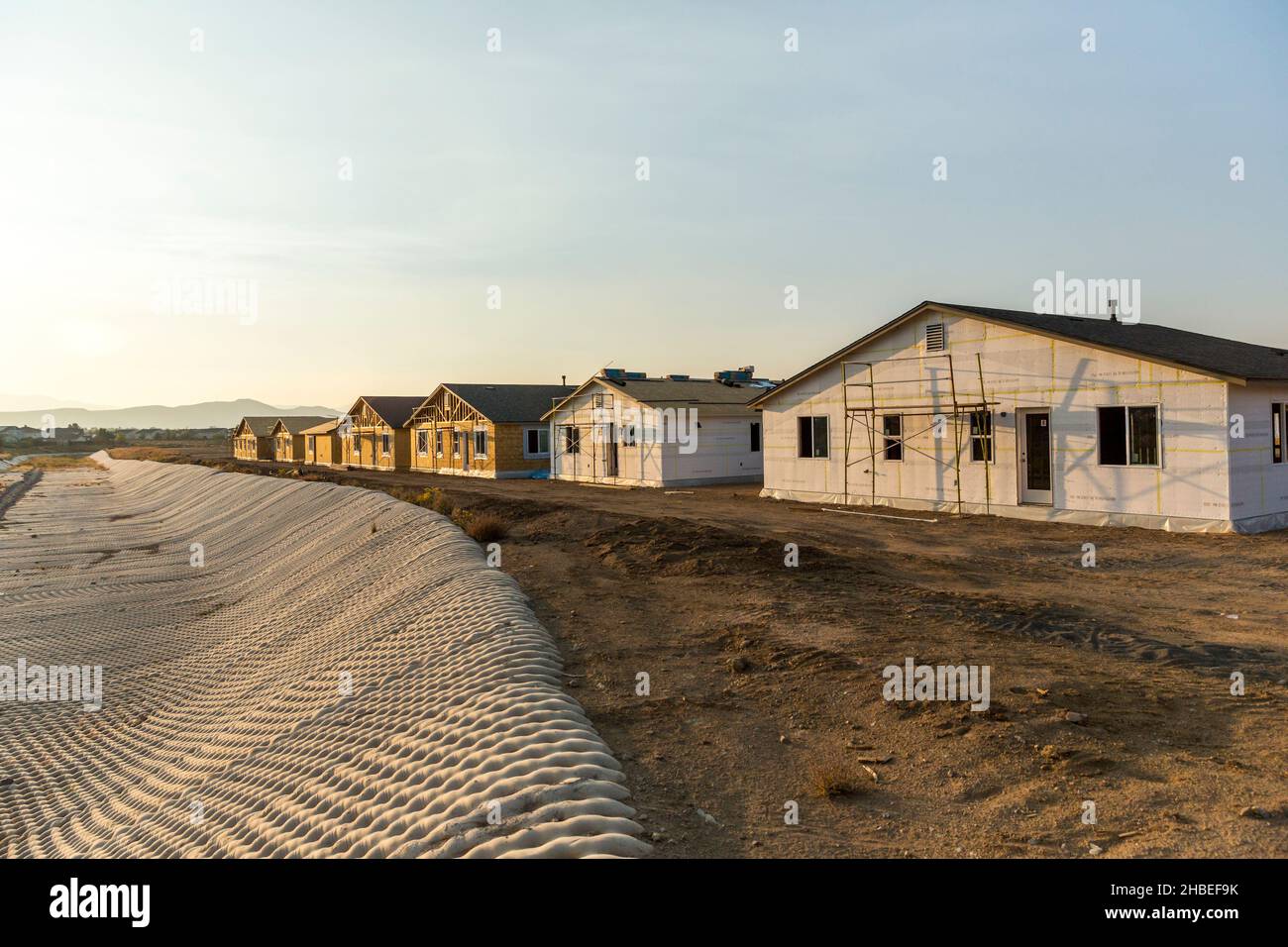 Rows of houses under construction with scaffolding next to a concrete ...