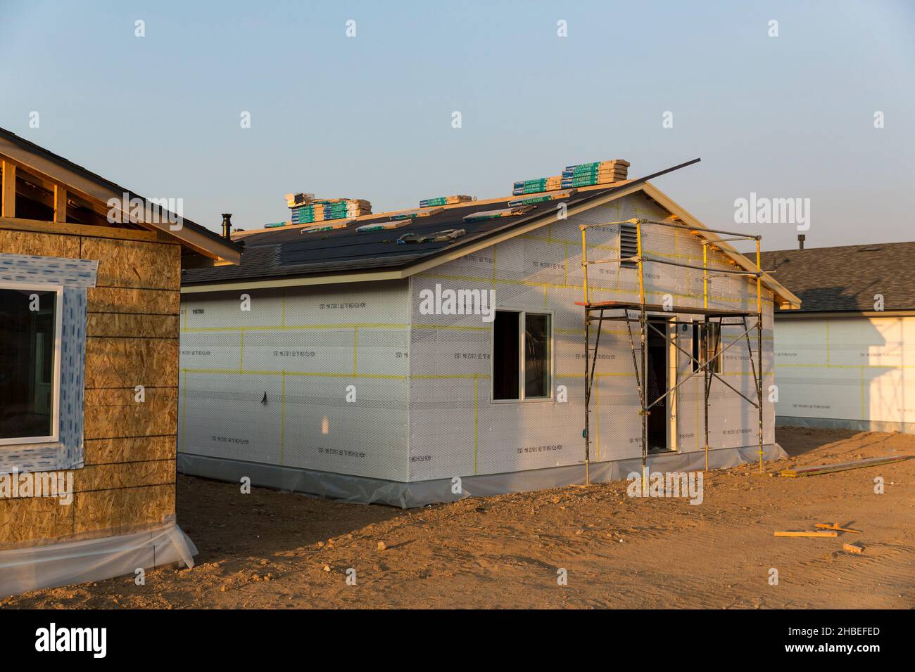 Unfinished housing with roofing shingles ready to be installed on top ...