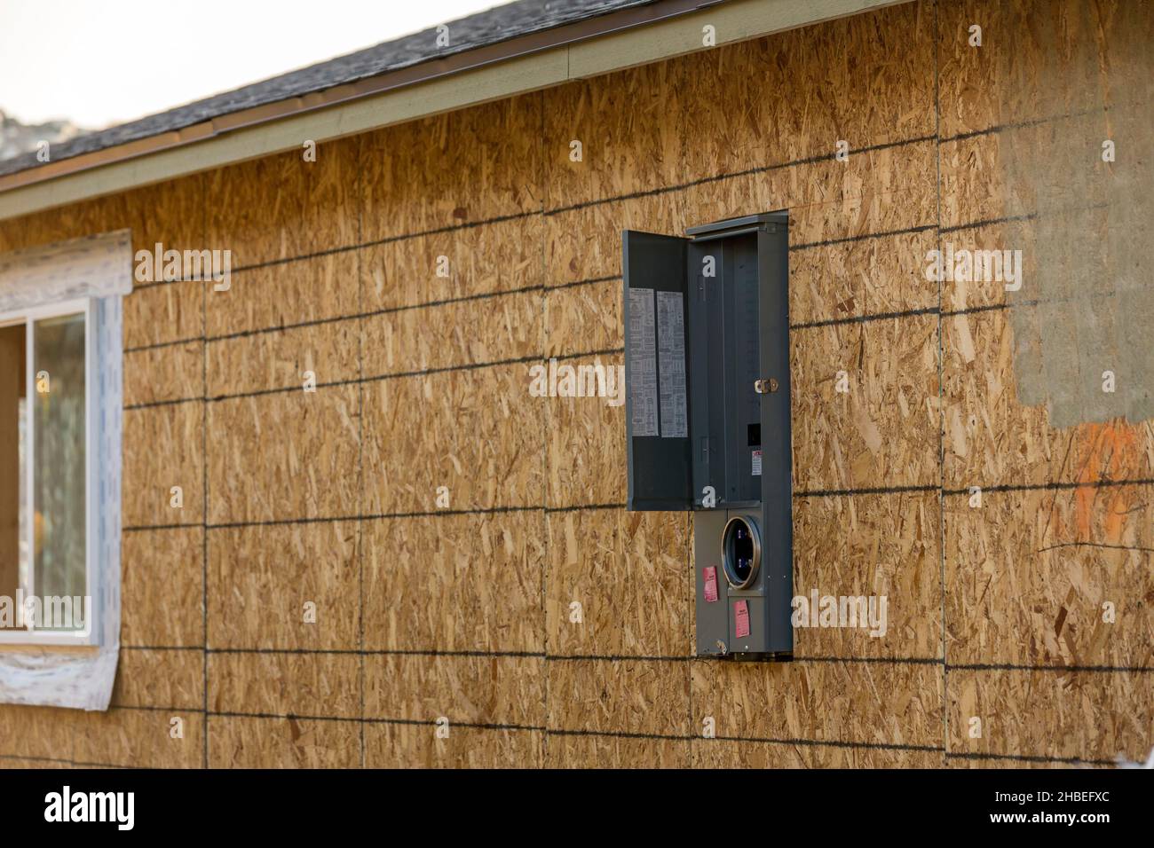 Electrical utilities and breaker box installed in a new plywood wall ...