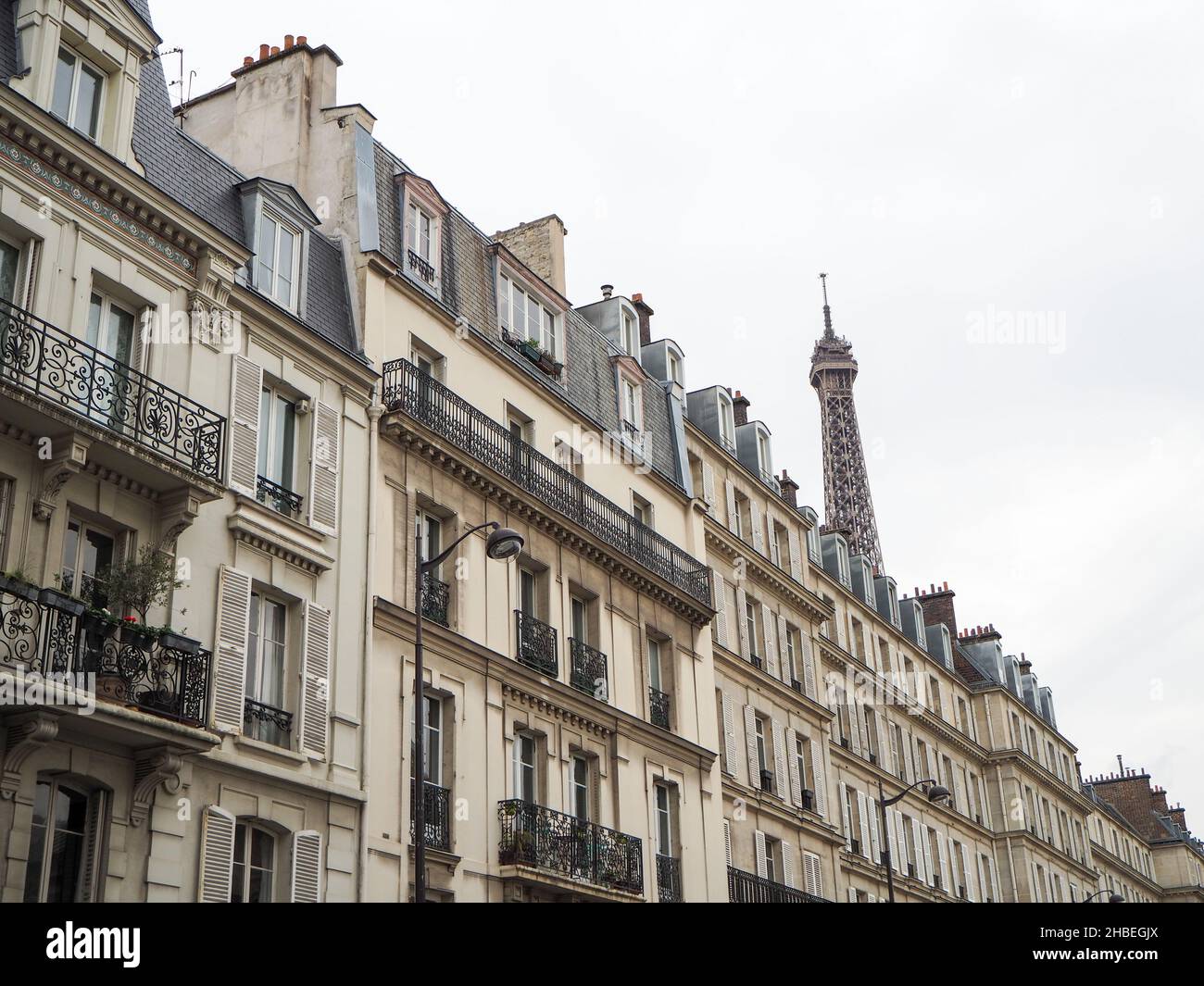 A shot of the famous Eiffel tower behind buildings in Paris, France ...