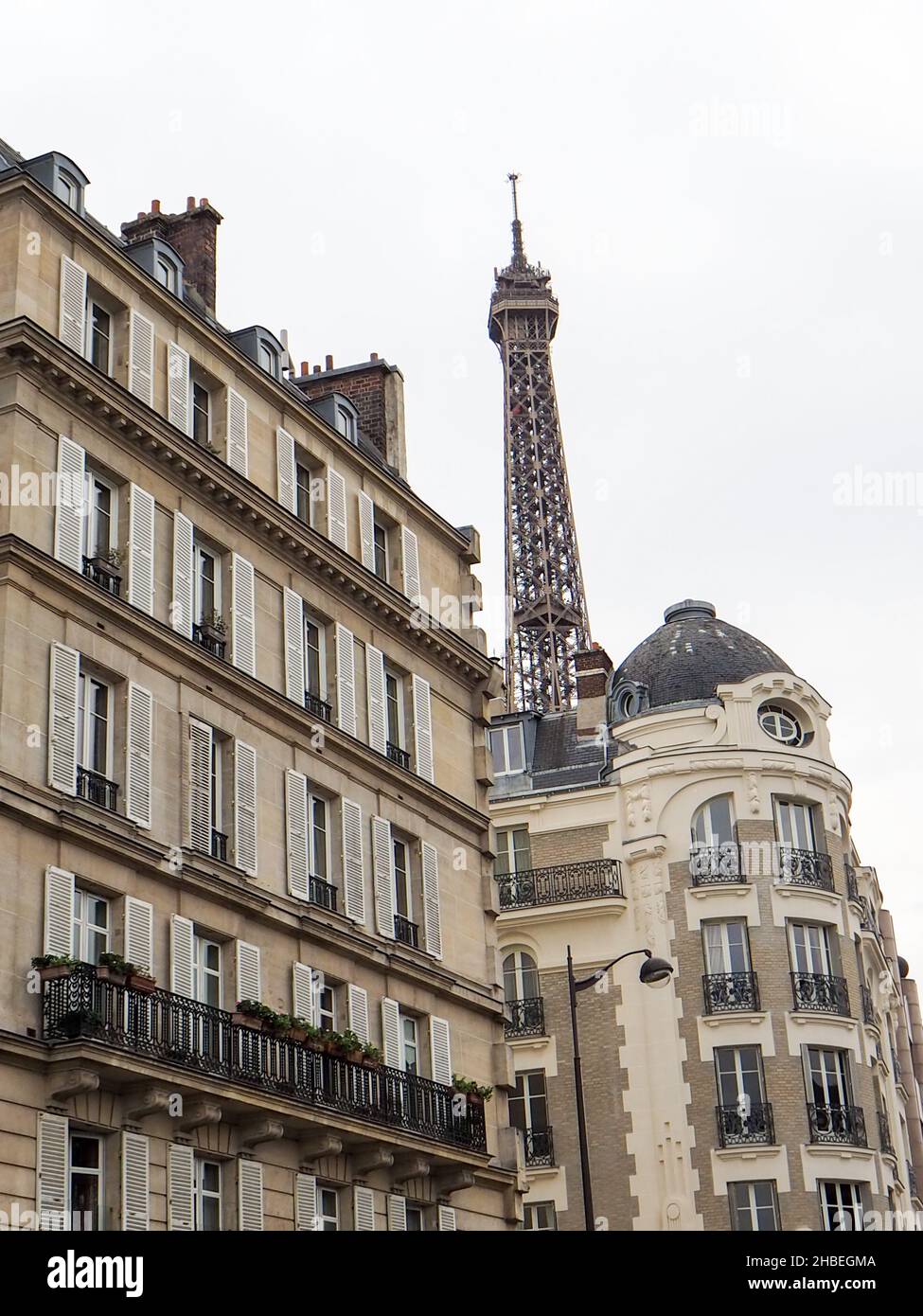 A shot of the famous Eiffel tower behind buildings in Paris, France ...