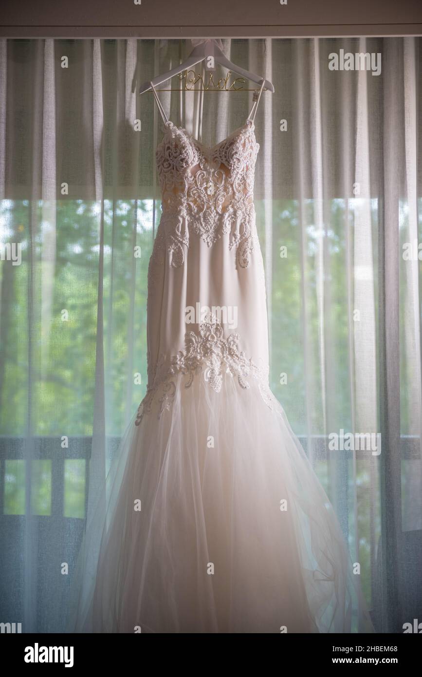 A vertical shot of the bridal evening gown hanging in the room Stock ...