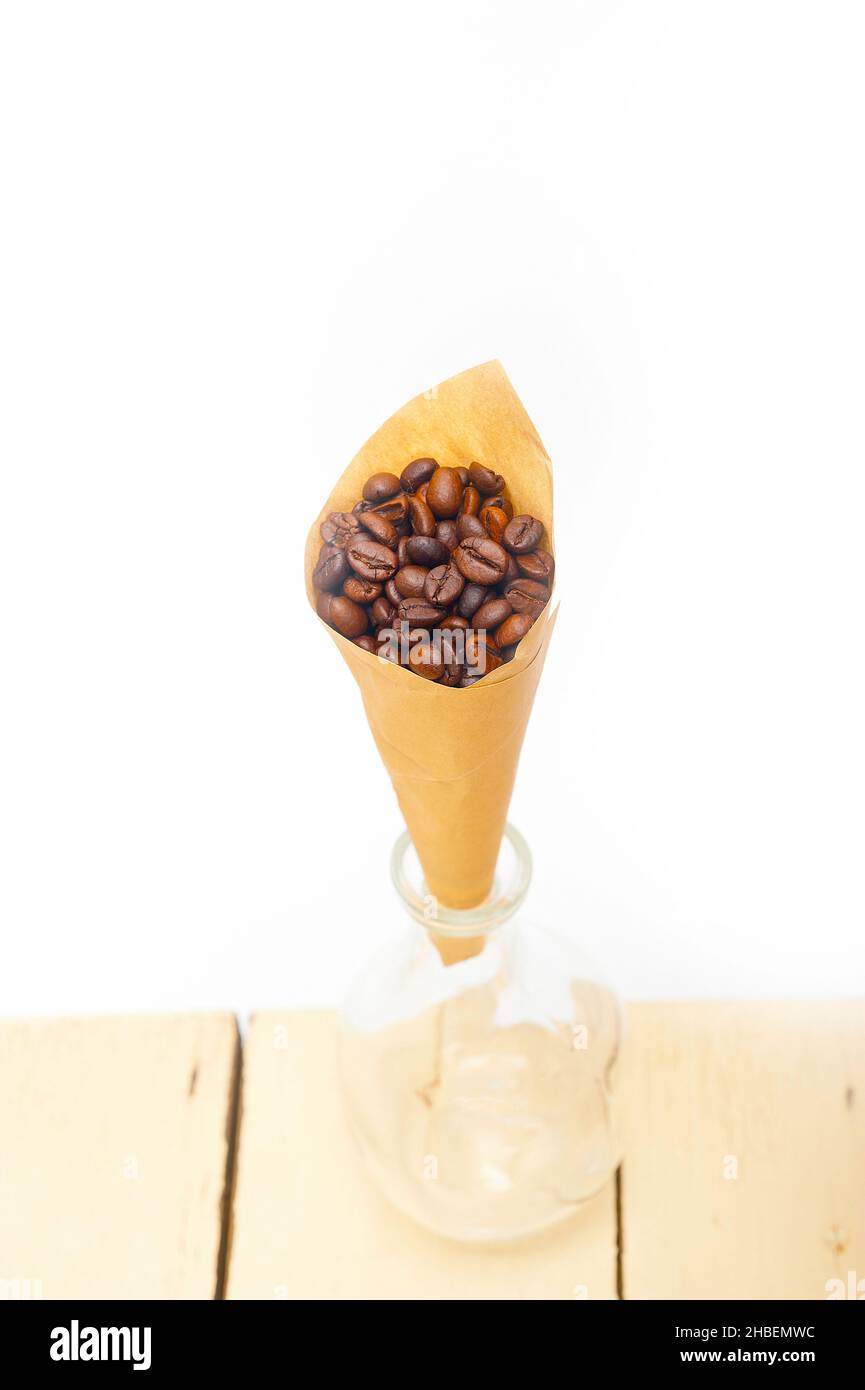 espresso coffee beans on a paper cone cornucopia over white background ...