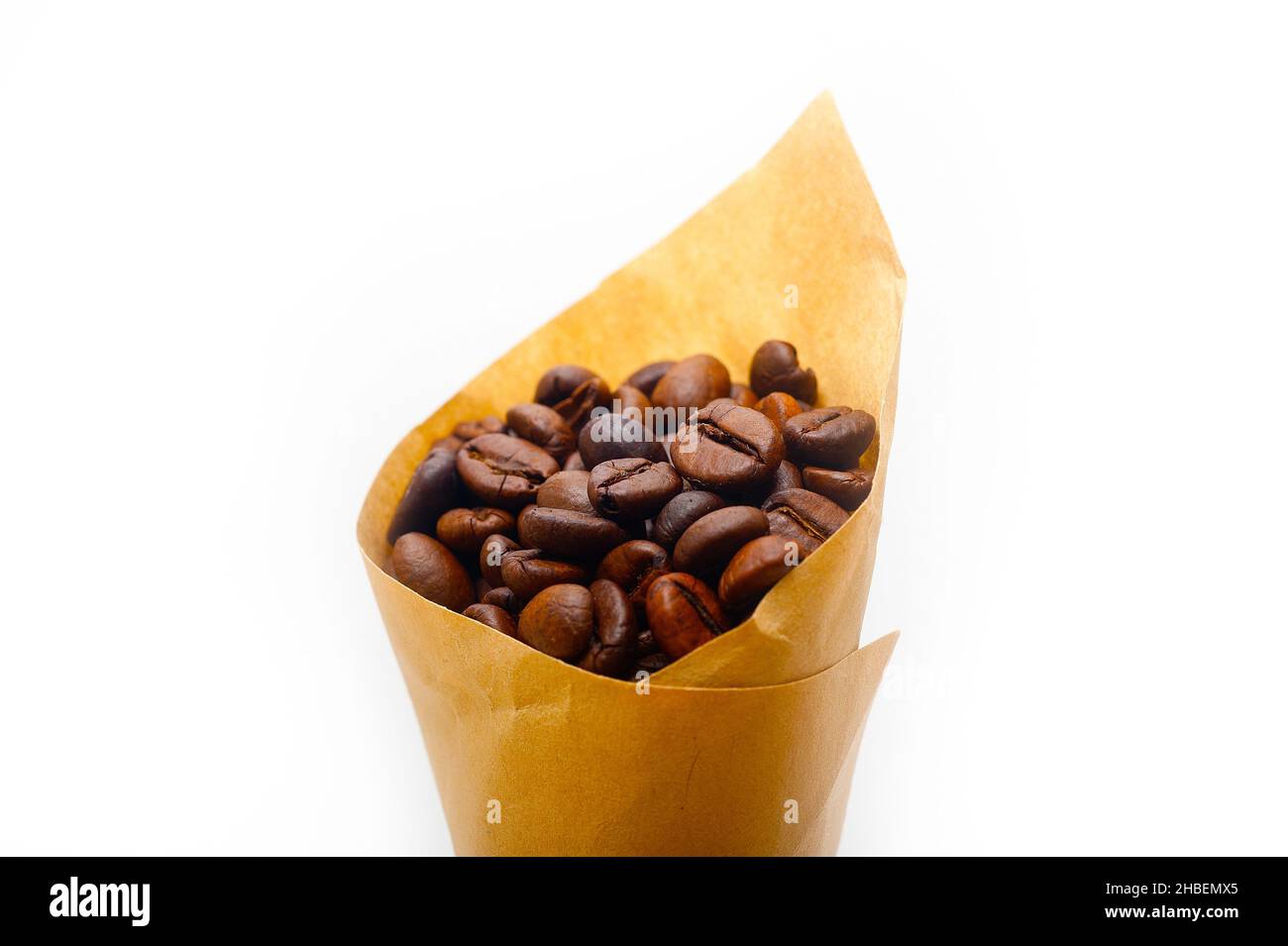 espresso coffee beans on a paper cone cornucopia over white background ...
