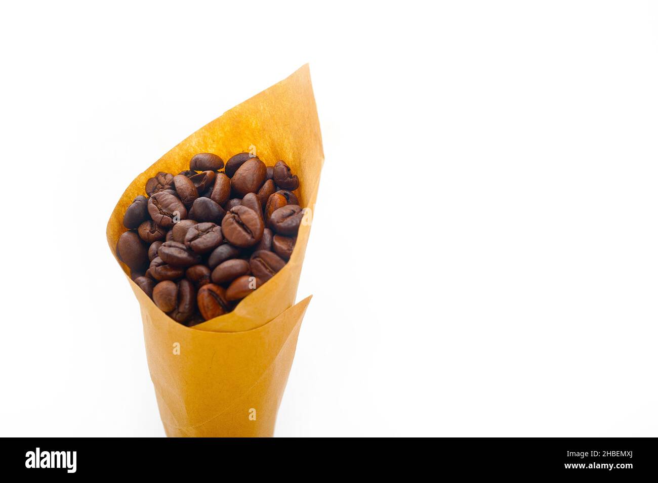 espresso coffee beans on a paper cone cornucopia over white background ...
