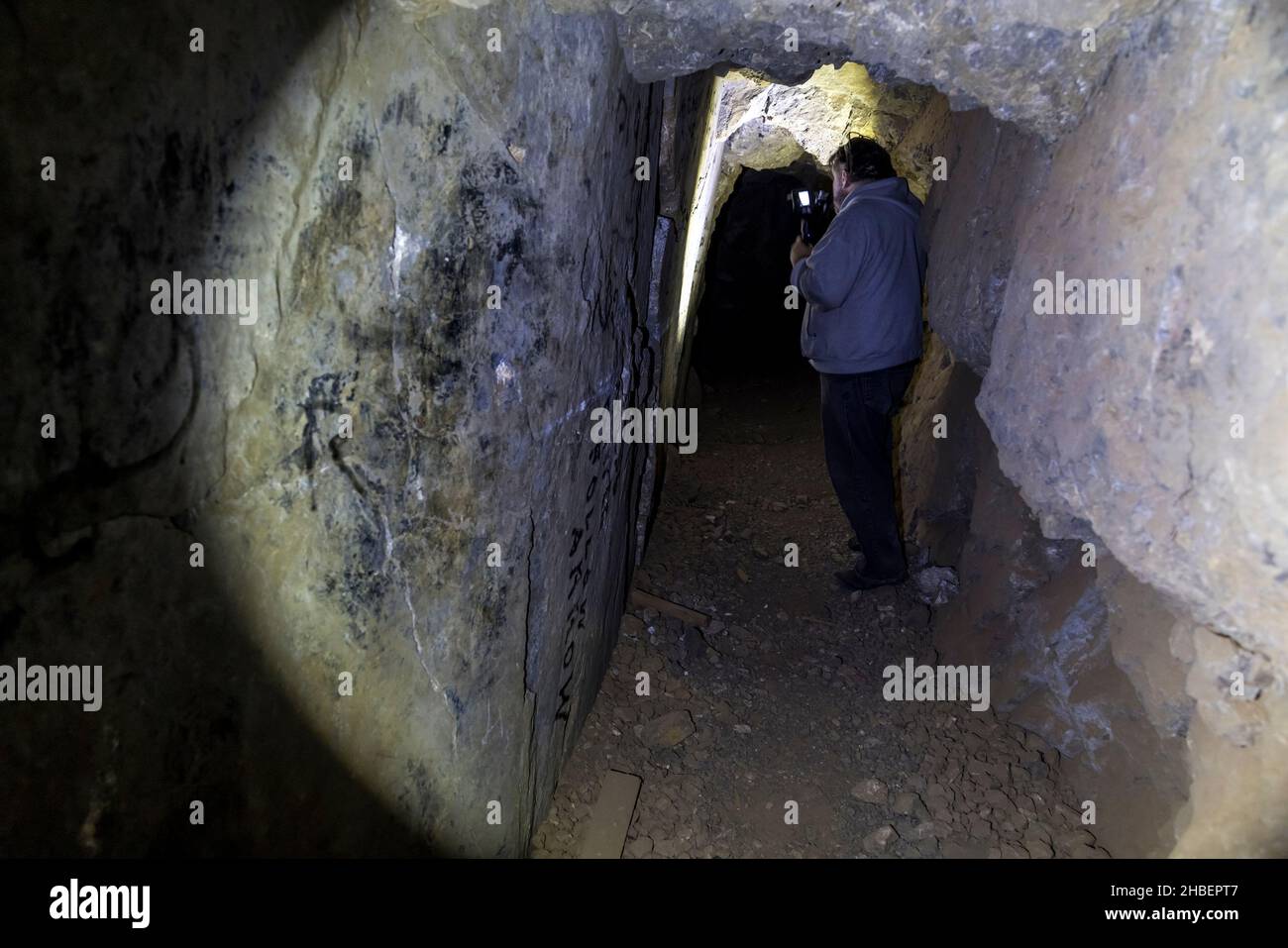 Man records the walls of a mine shaft using an action camara on a ...