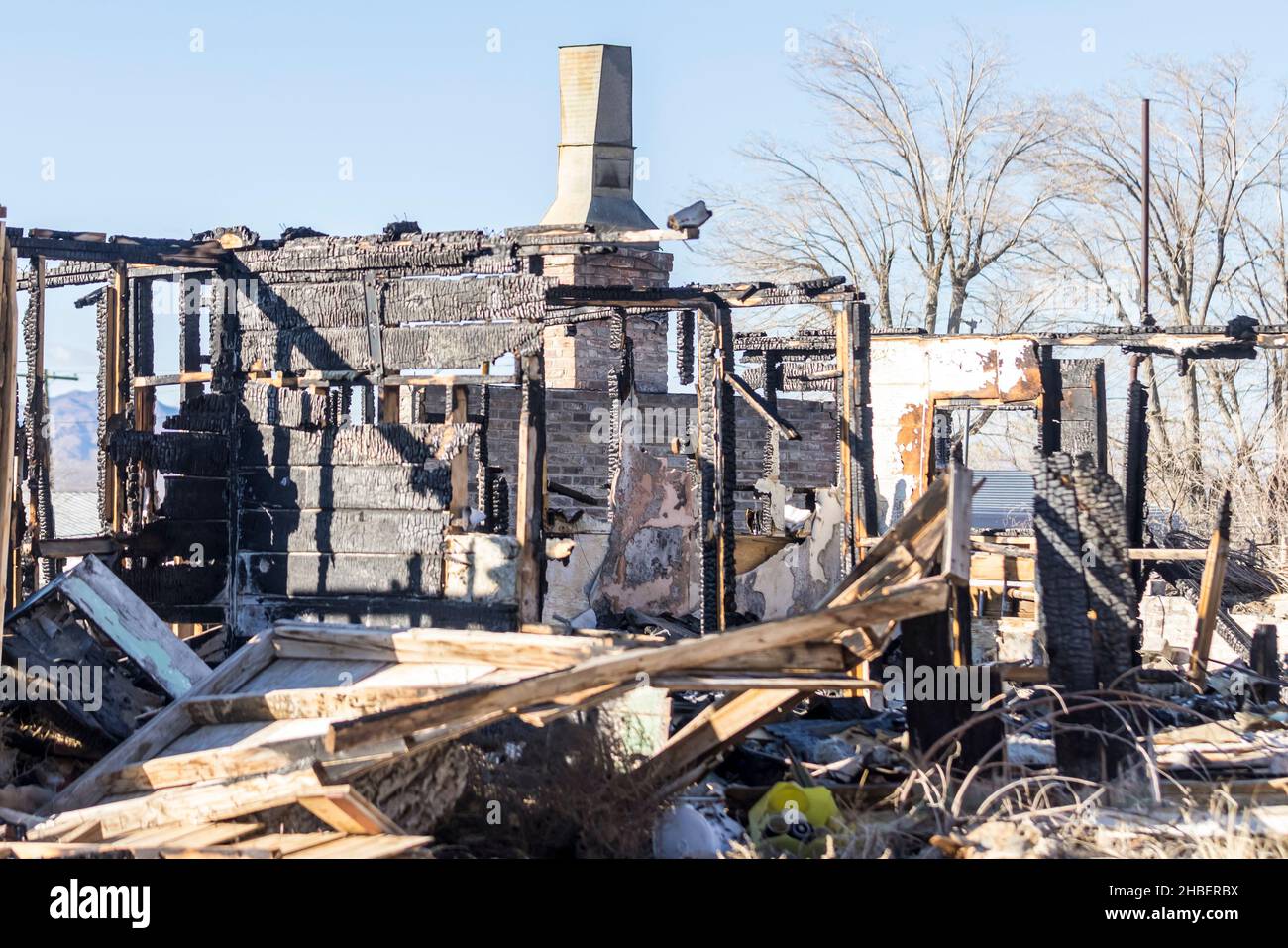 Burned walls and a brick chimney are all that are left after a house ...
