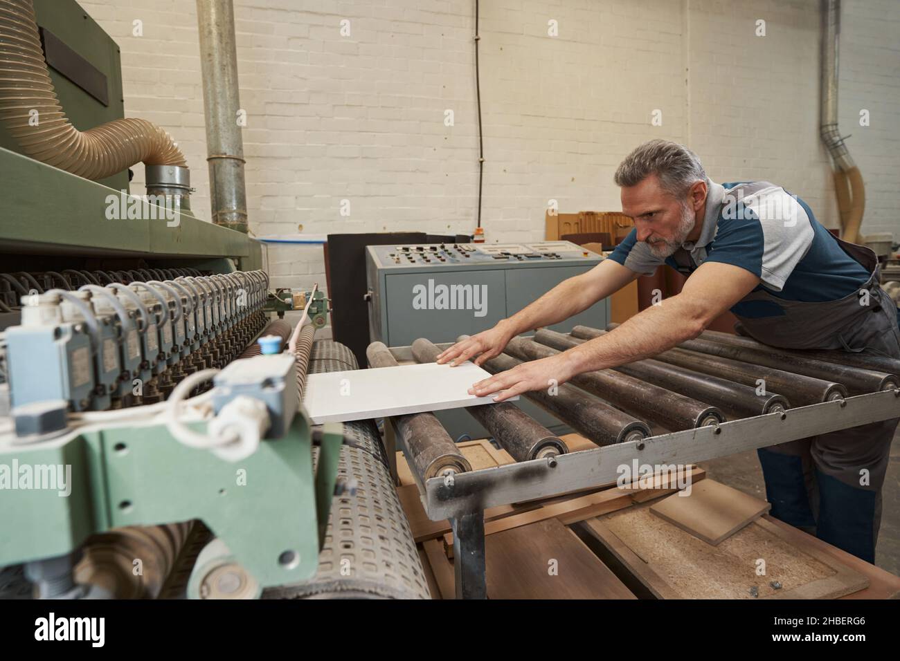 Competent aged carpenter gluing borders of veneer Stock Photo - Alamy