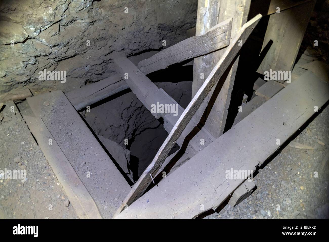 Dust covered timbers protect a mining shaft dug straight in the ground ...