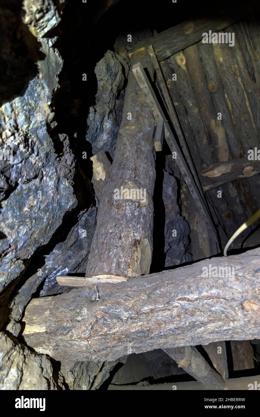 Sections of timber hold a wood platform up between the rocks in a mine ...
