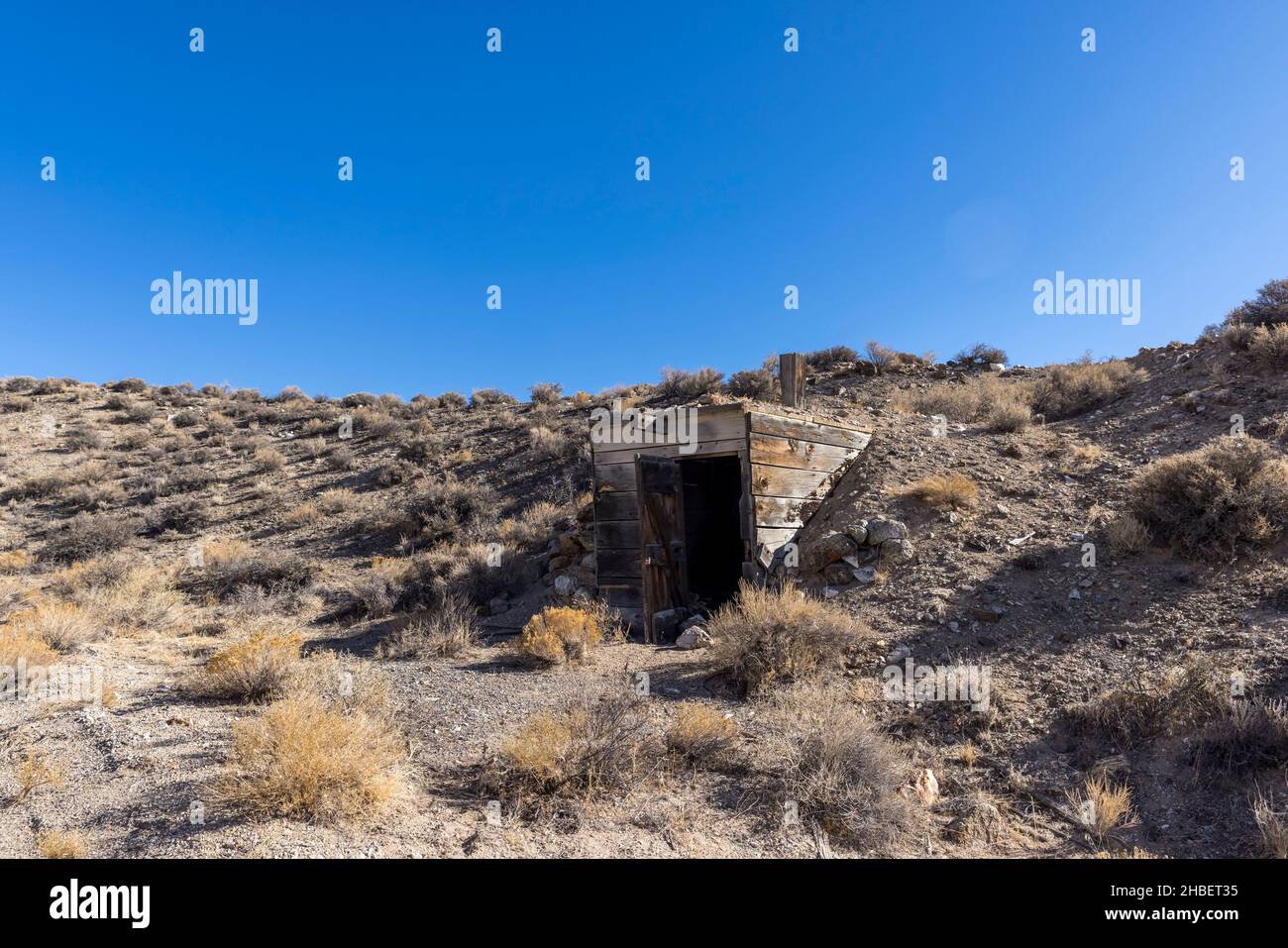 Old mining cabin with the door open set into the side of a hill in the ...