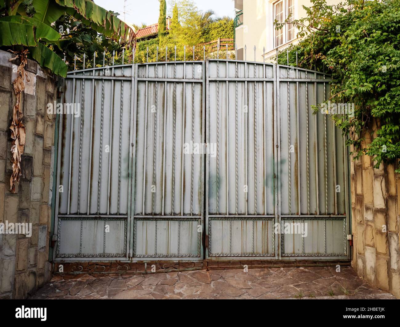 Large gates with wrought iron elements front view Stock Photo - Alamy