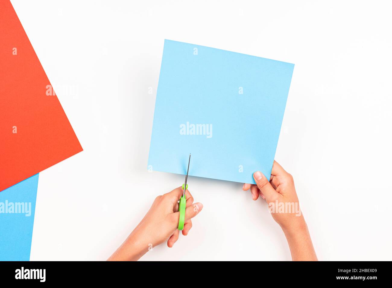 Kid cutting colored paper with scissors in his left hand. Education ...